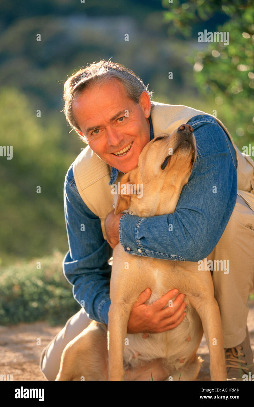 Man posing embracing dog Stock Photo - Alamy