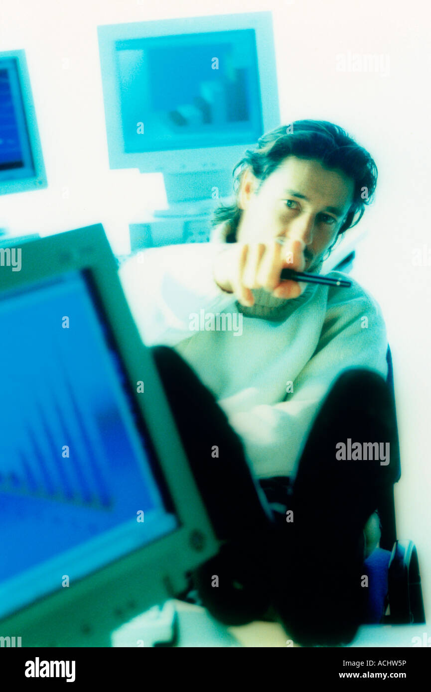Man seated in office streching out his legs pointing camera Stock Photo ...