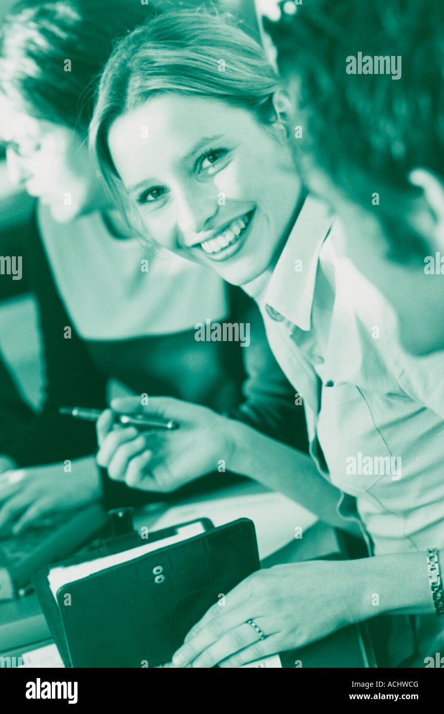 Portrait blond woman about to write smiling in a group Stock Photo - Alamy
