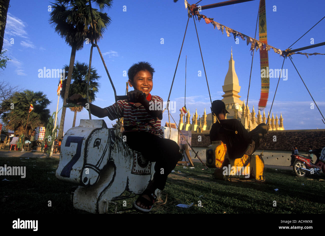 Asia Laos Vientiane Young boy on carnival ride at small fair just ...