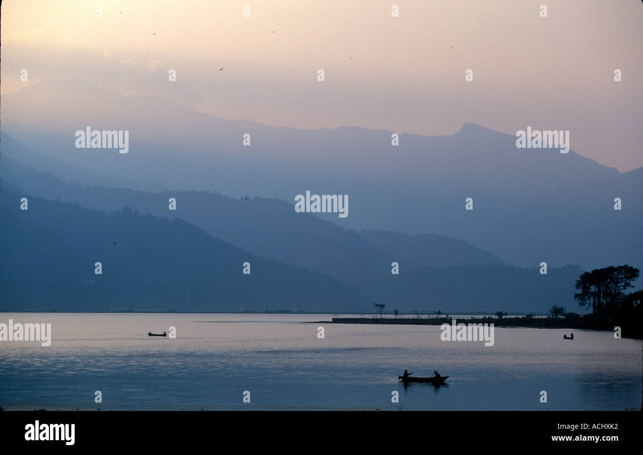 Nepal Pokhara Fishermen paddle wooden boats through Phewa Tal lake in ...