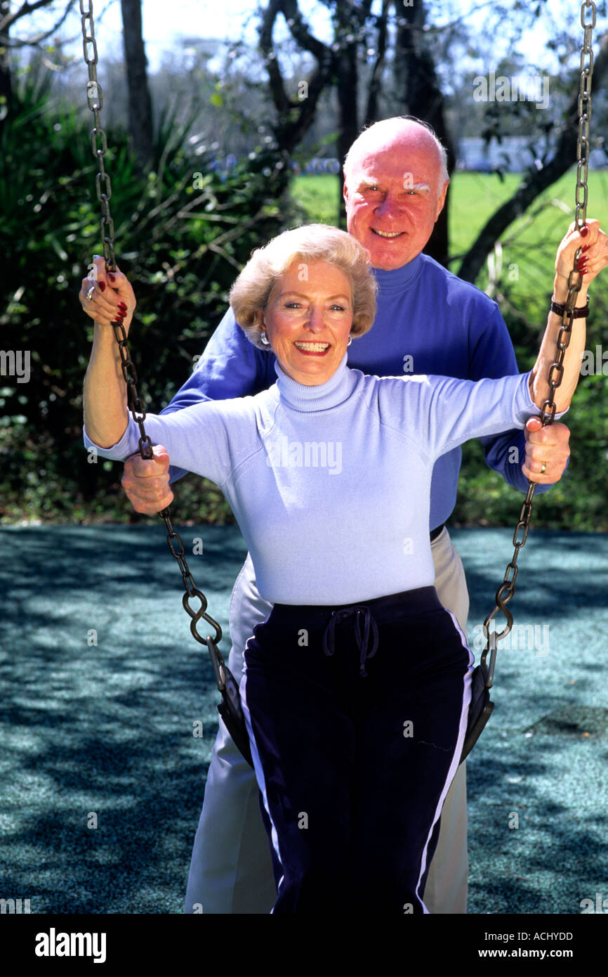 Healthy retired couple in their 70s on a swing Stock Photo - Alamy