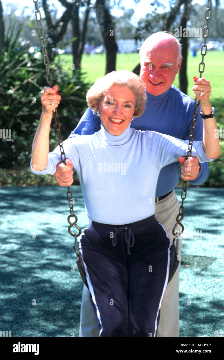 Healthy retired couple in their 70s on a swing Stock Photo - Alamy