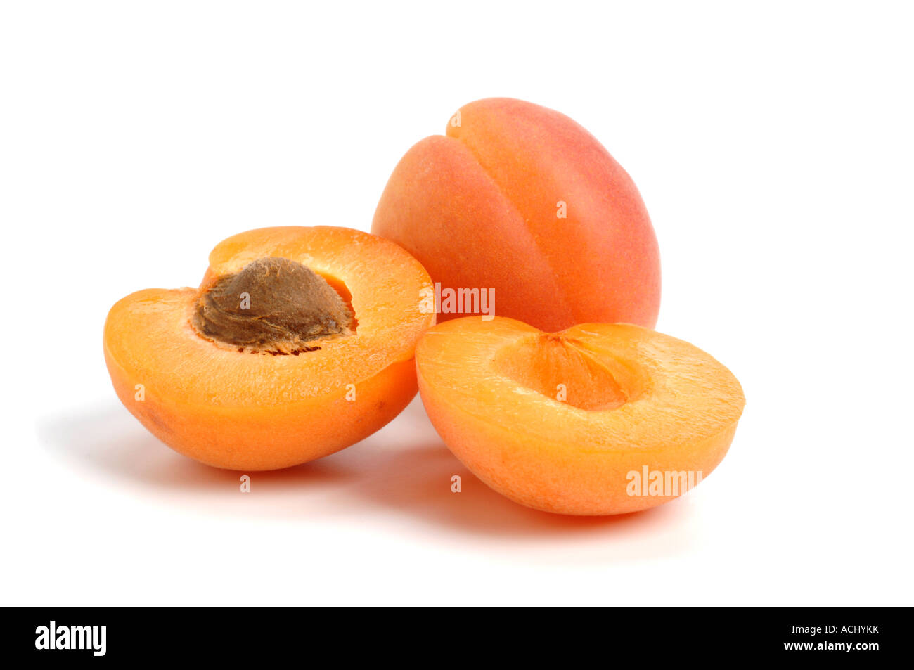 Apricots one halved showing stone on white background Stock Photo - Alamy
