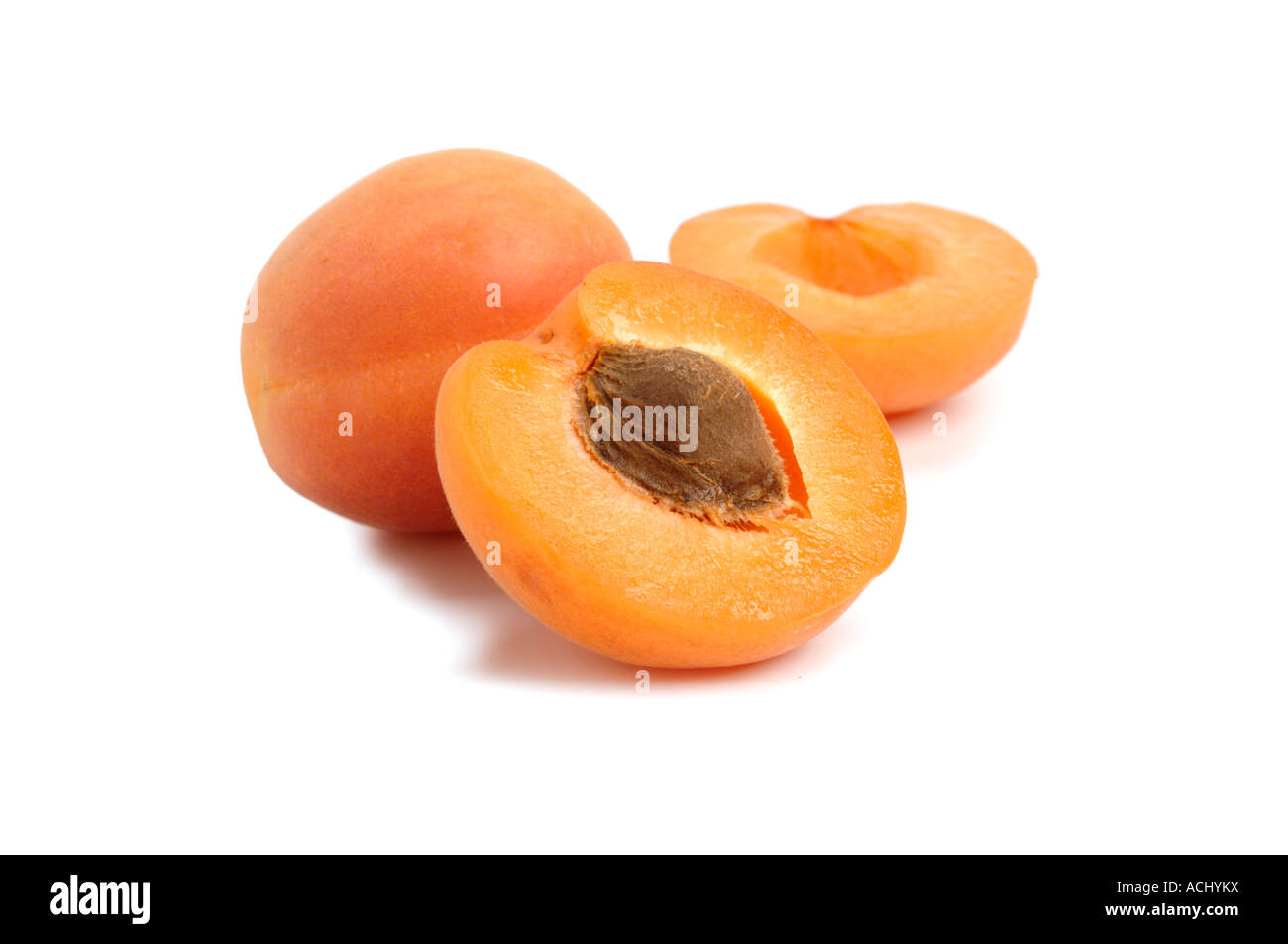 Apricots, one halved showing stone, on white background Stock Photo - Alamy