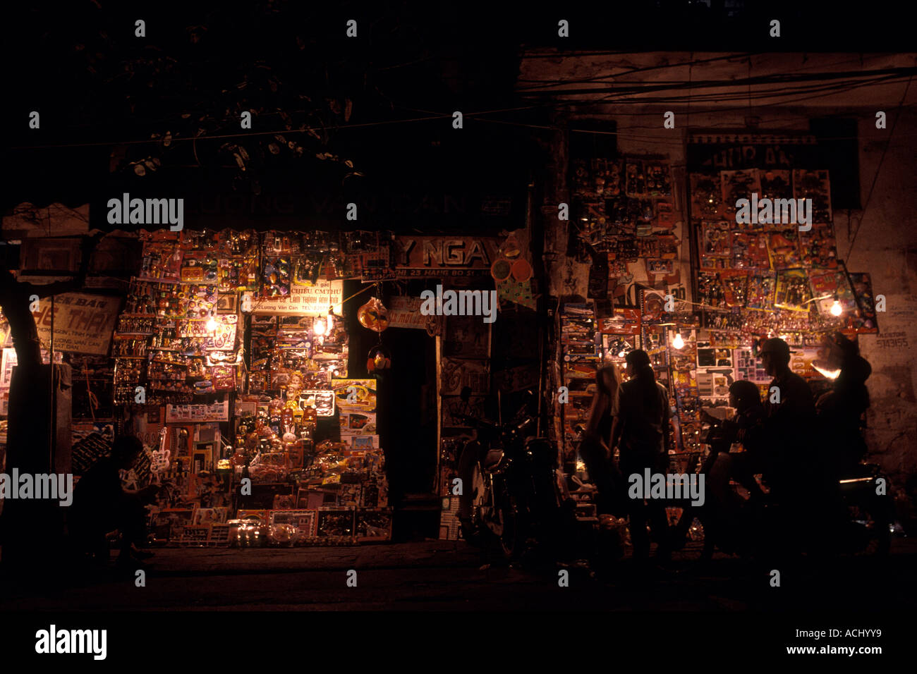 Asia Vietnam Hanoi Shoppers stand outside comic book shop along busy ...