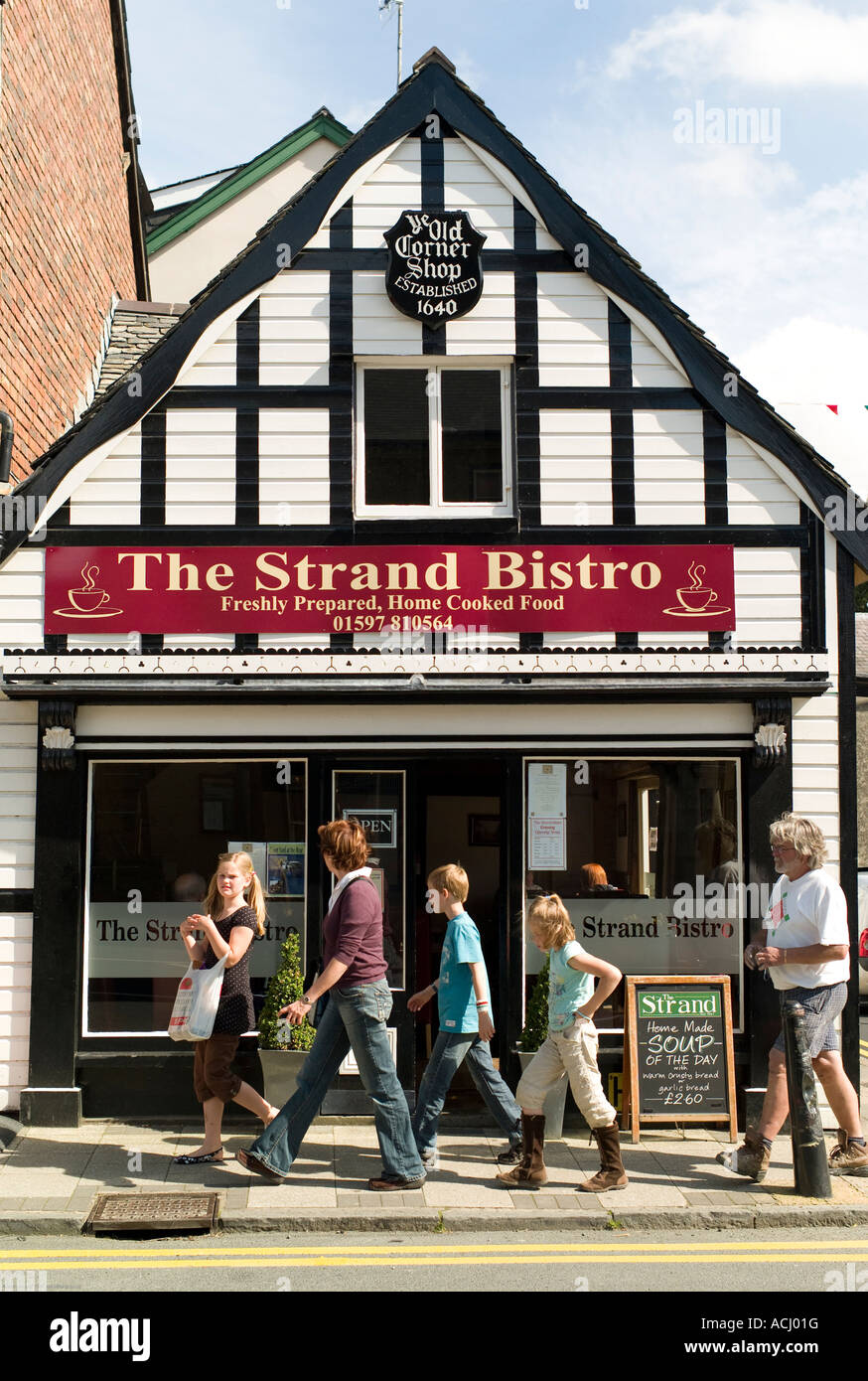 Family walking past the Strand Bistro cafe restaurant Rhayader Powys ...
