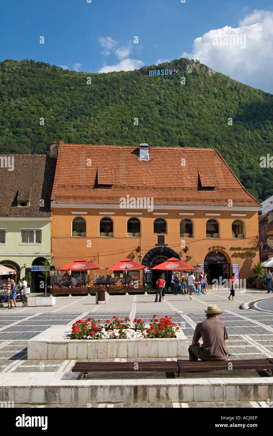 Brasov, Transylvania, Romania. Piata Sfatului (main square) Man sitting ...
