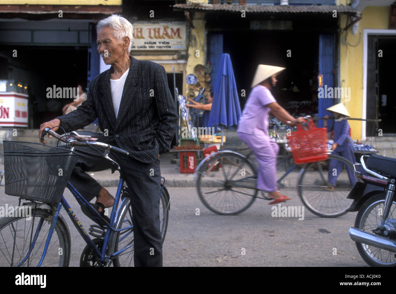 Asia Vietnam Hoi An Man stands by bicycle on busy street along Thu Bon ...
