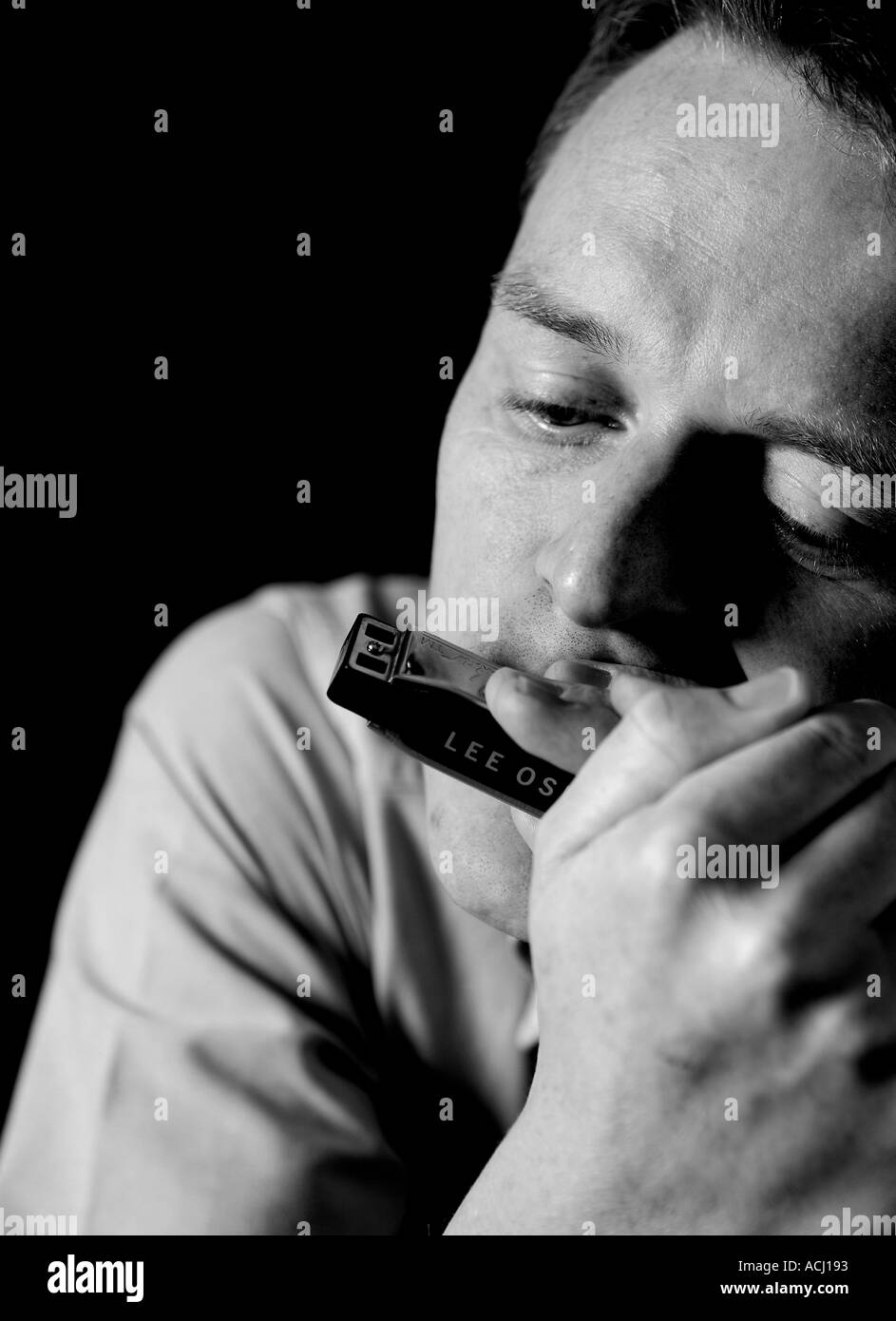 harmonica practice at home concentration on his face in black and white ...