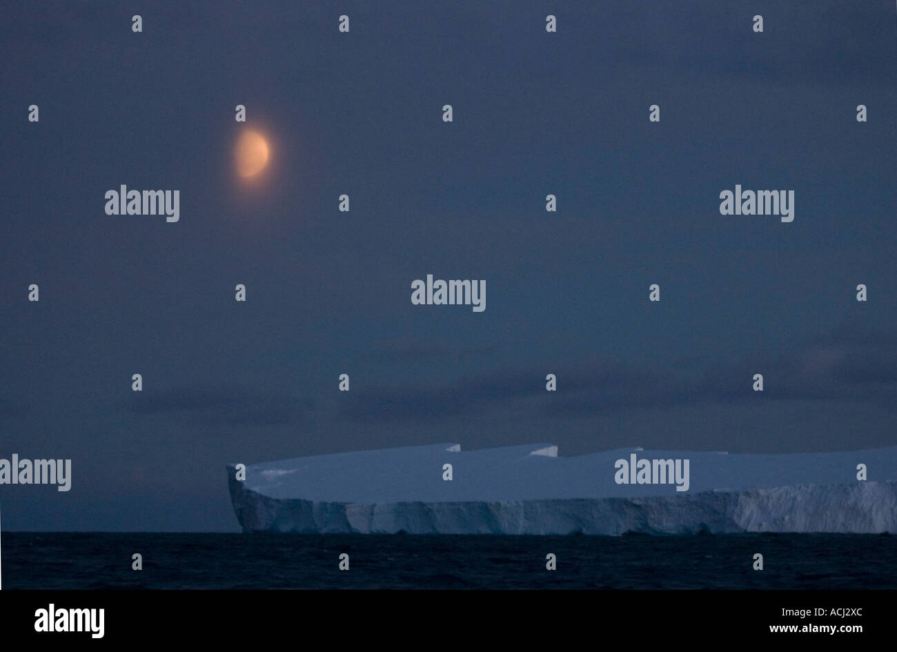 Antarctica Gibbous moon rises above massive tabular iceberg in ...