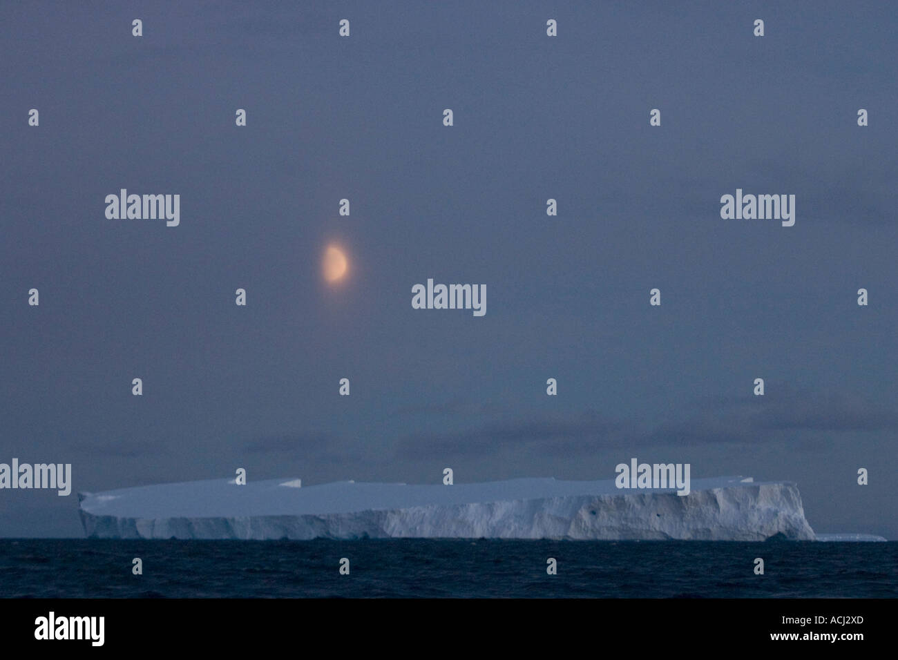 Antarctica Gibbous moon rises above massive tabular iceberg in ...
