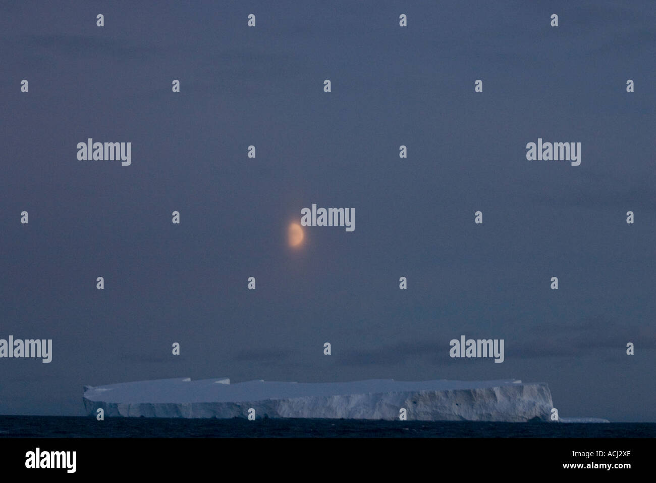 Antarctica Gibbous moon rises above massive tabular iceberg in ...