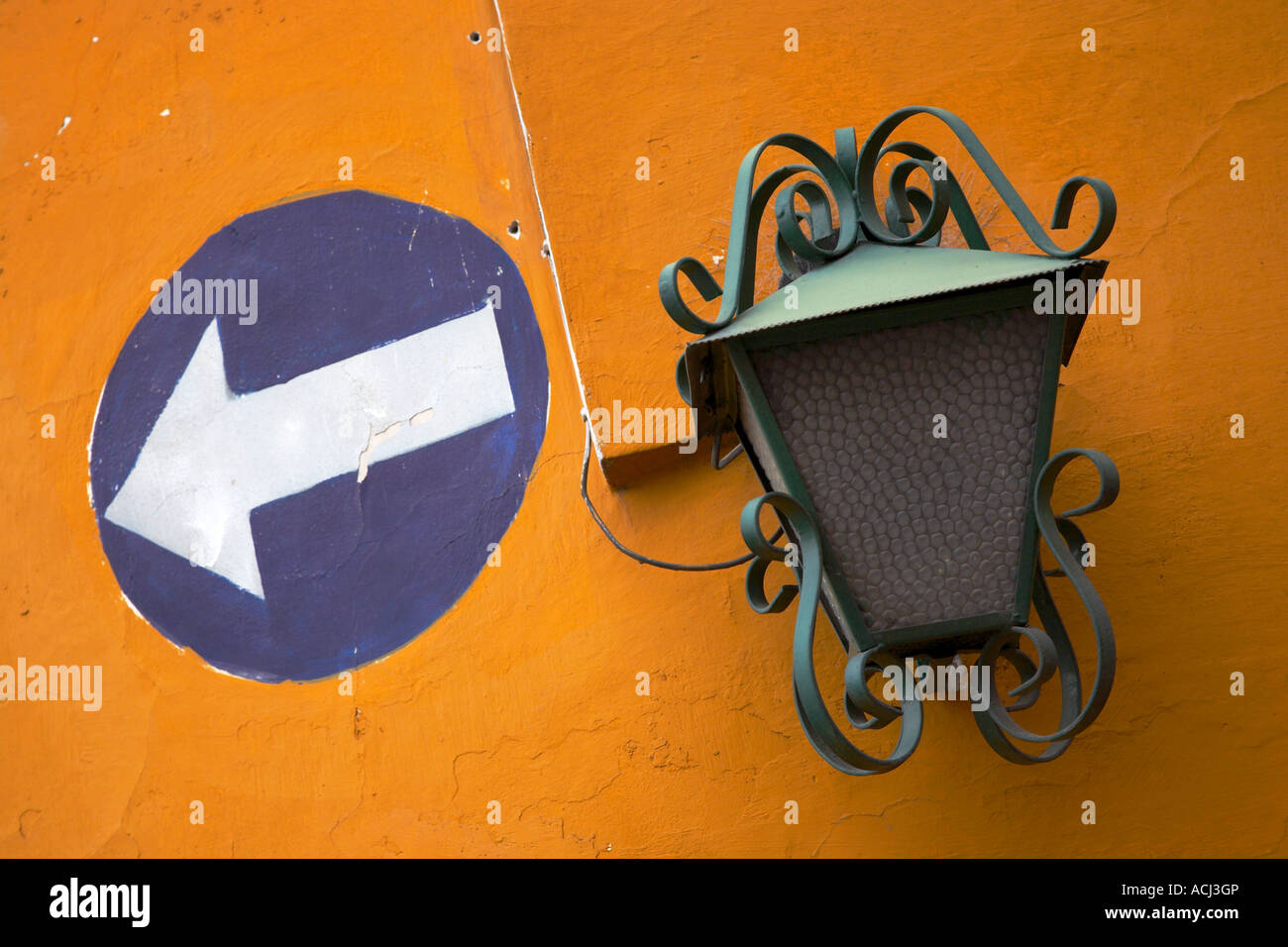 yellow wall with street light and arrow sign Stock Photo - Alamy