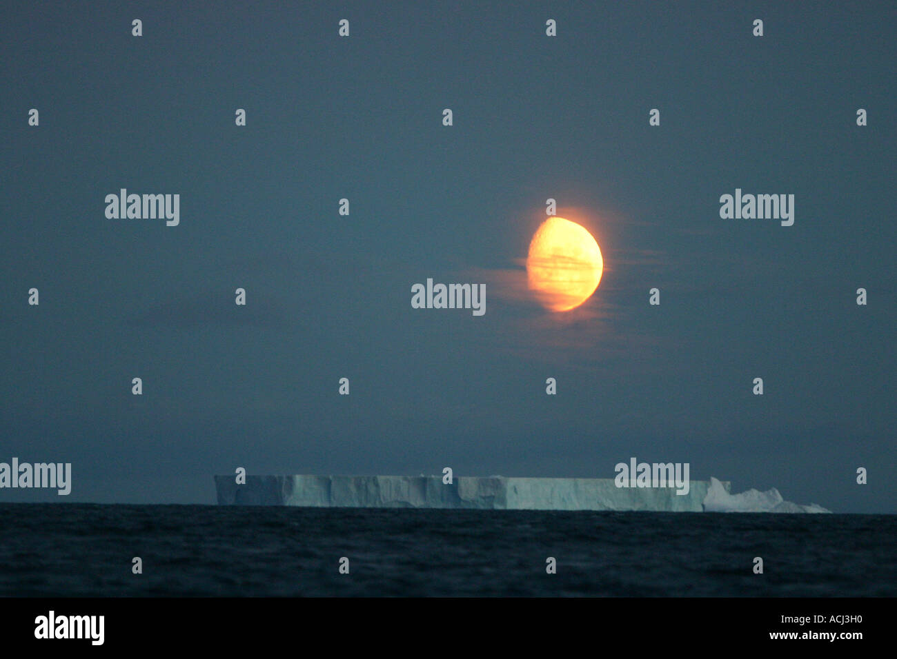 Antarctica Gibbous moon rises above massive tabular iceberg in ...