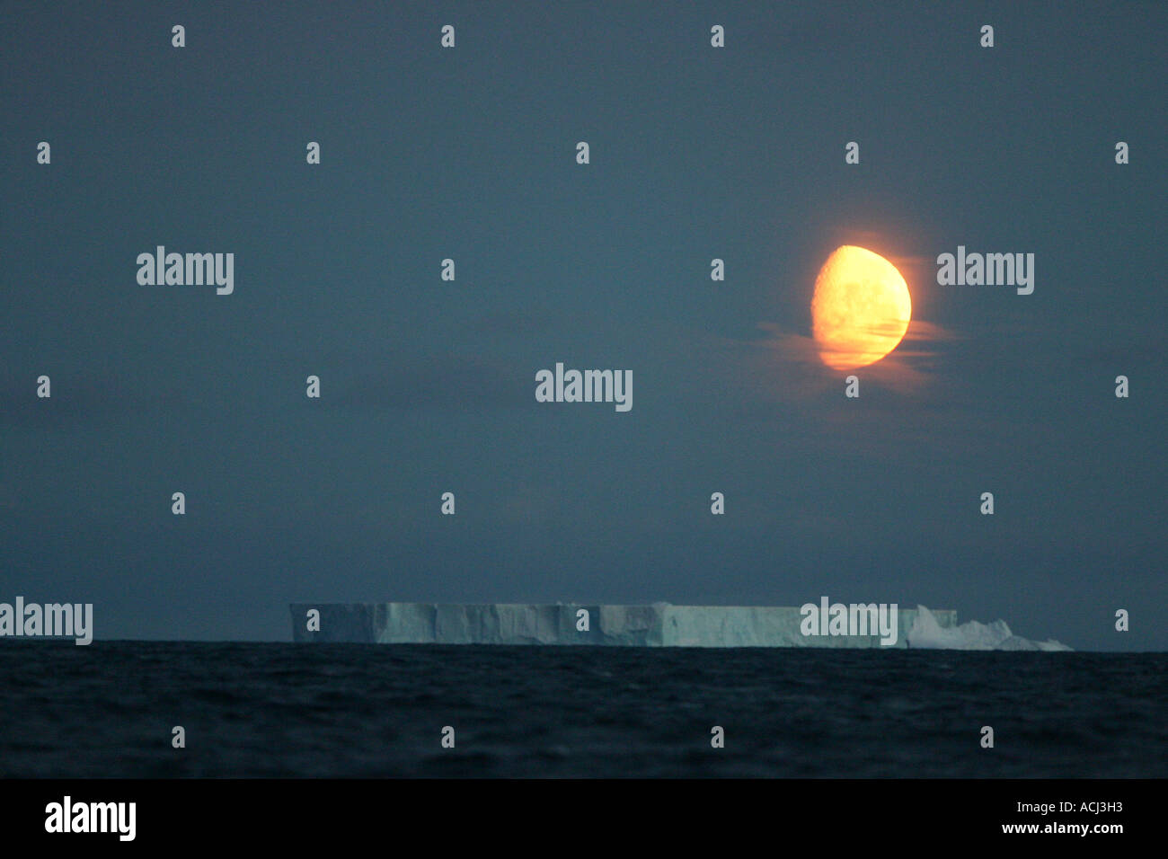 Antarctica Gibbous moon rises above massive tabular iceberg in ...