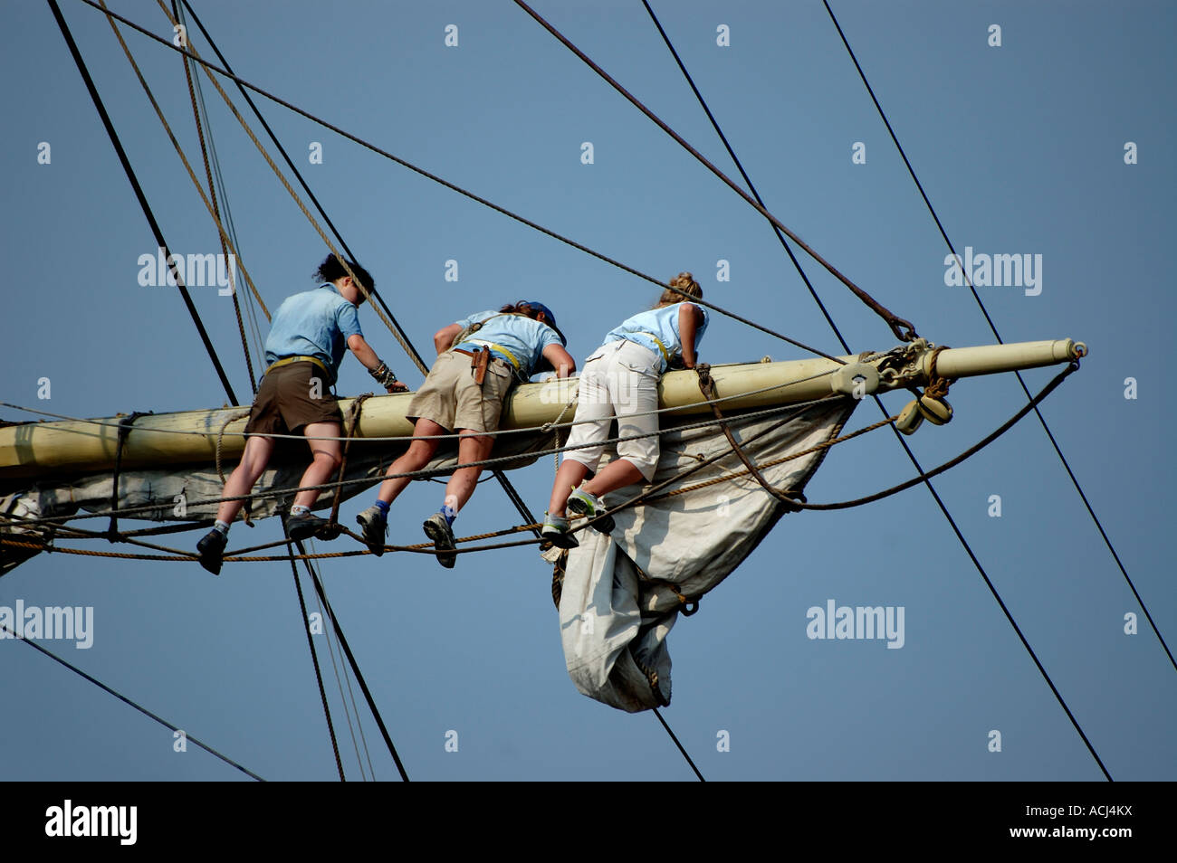 Standing on the footropes to stow the sails on a square rigged ship at ...