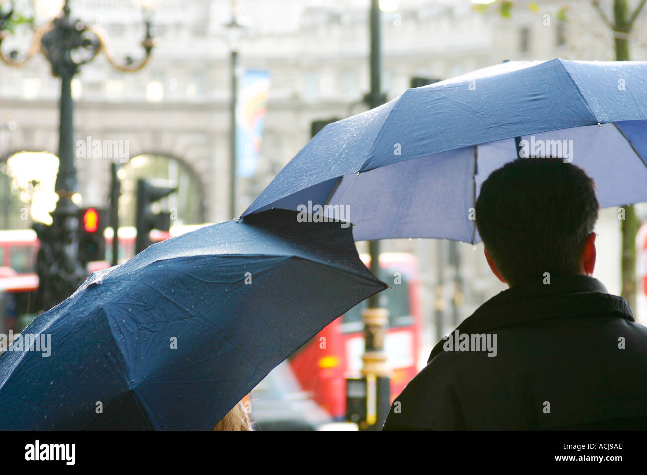 People under umbrellas standing in rain Trafalgar Square London Stock ...