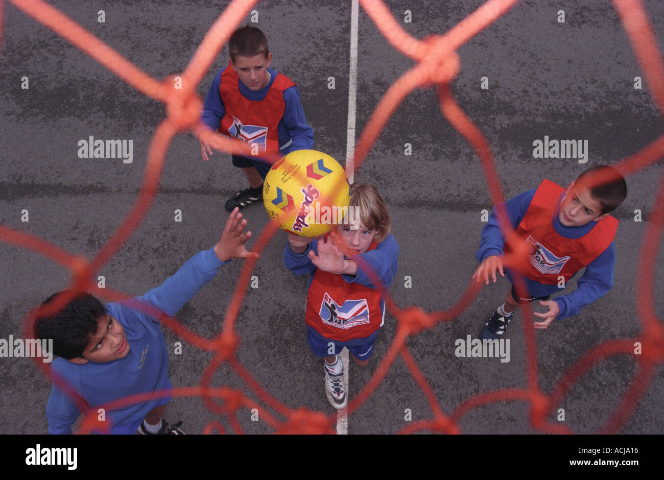 Primary school children playing basketball in school playground ...