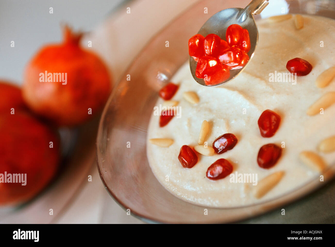 Composition pine nut cream grenade behind spoon with grenade grains ...