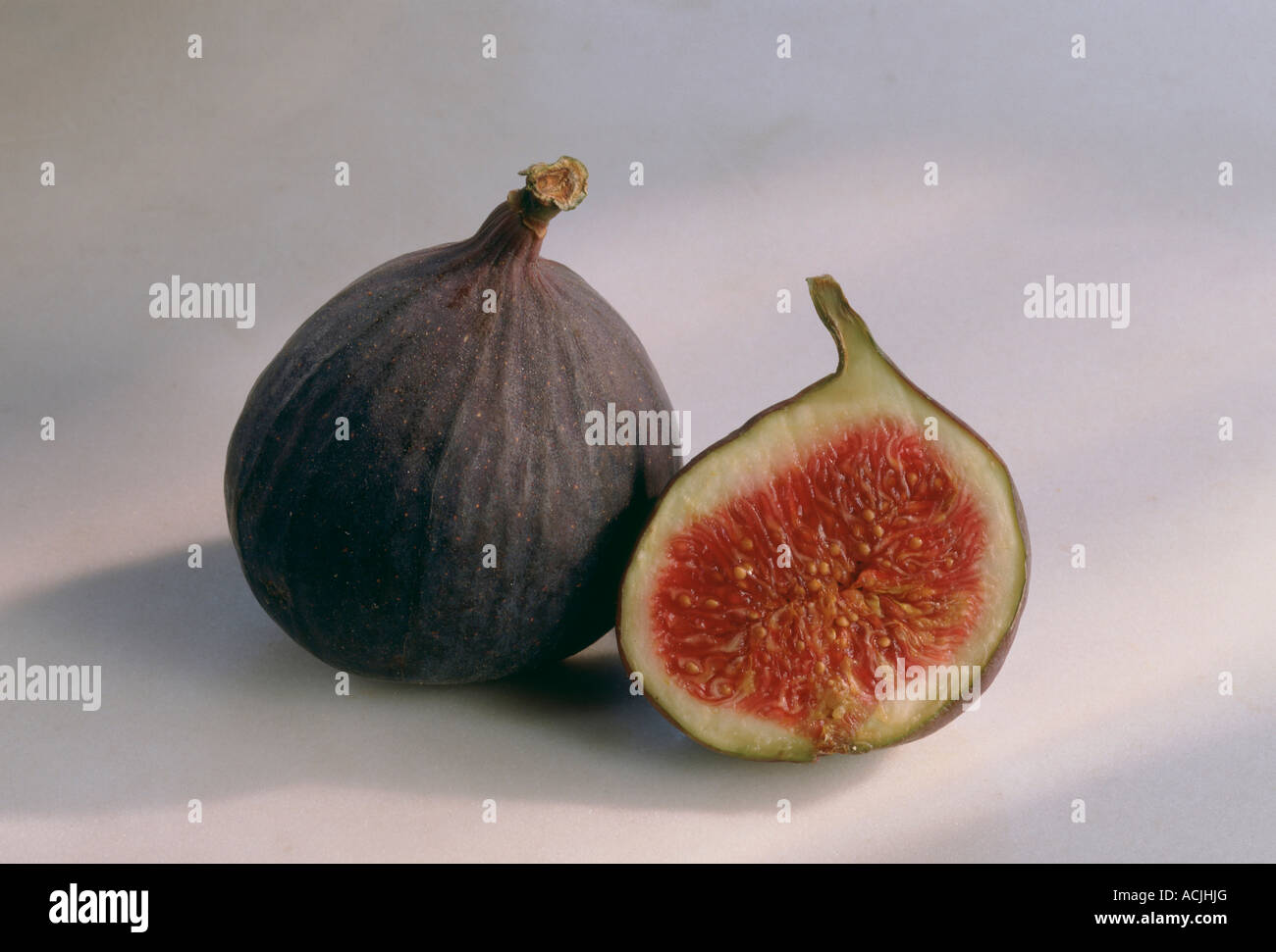 Fresh fig one cut in a half white background Stock Photo - Alamy