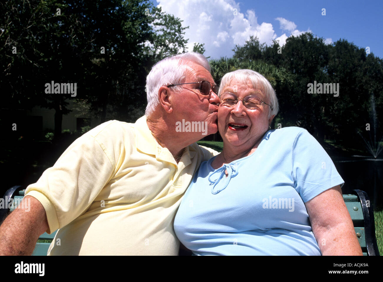 Healthy romantic retired senior couple have fun park on park bench ...