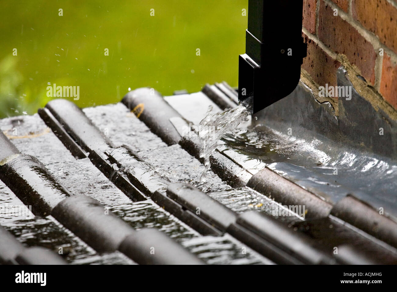 RAIN POURING OUT OF A DOWN PIPE ON A ROOF Stock Photo - Alamy