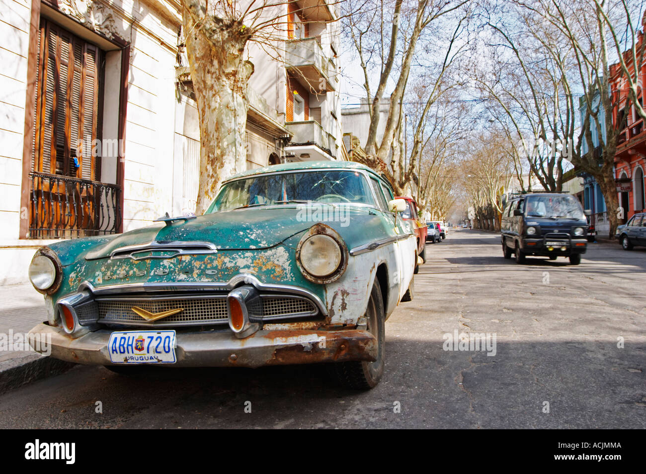 An old car rusty and flaky colour parked in the street, Green and white ...