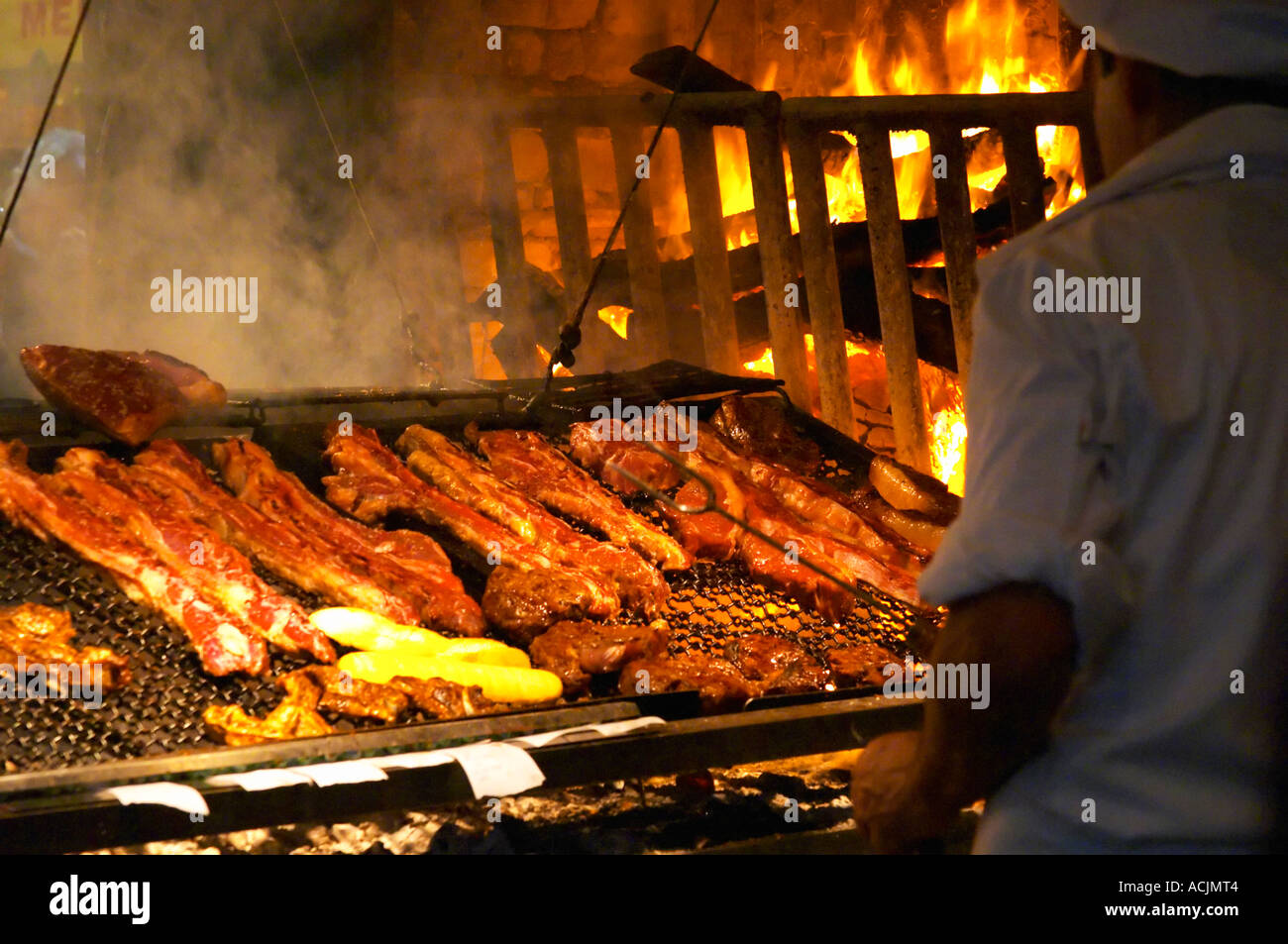 The gigantic huge charcoal grill with pieces of meat being cooked, the ...