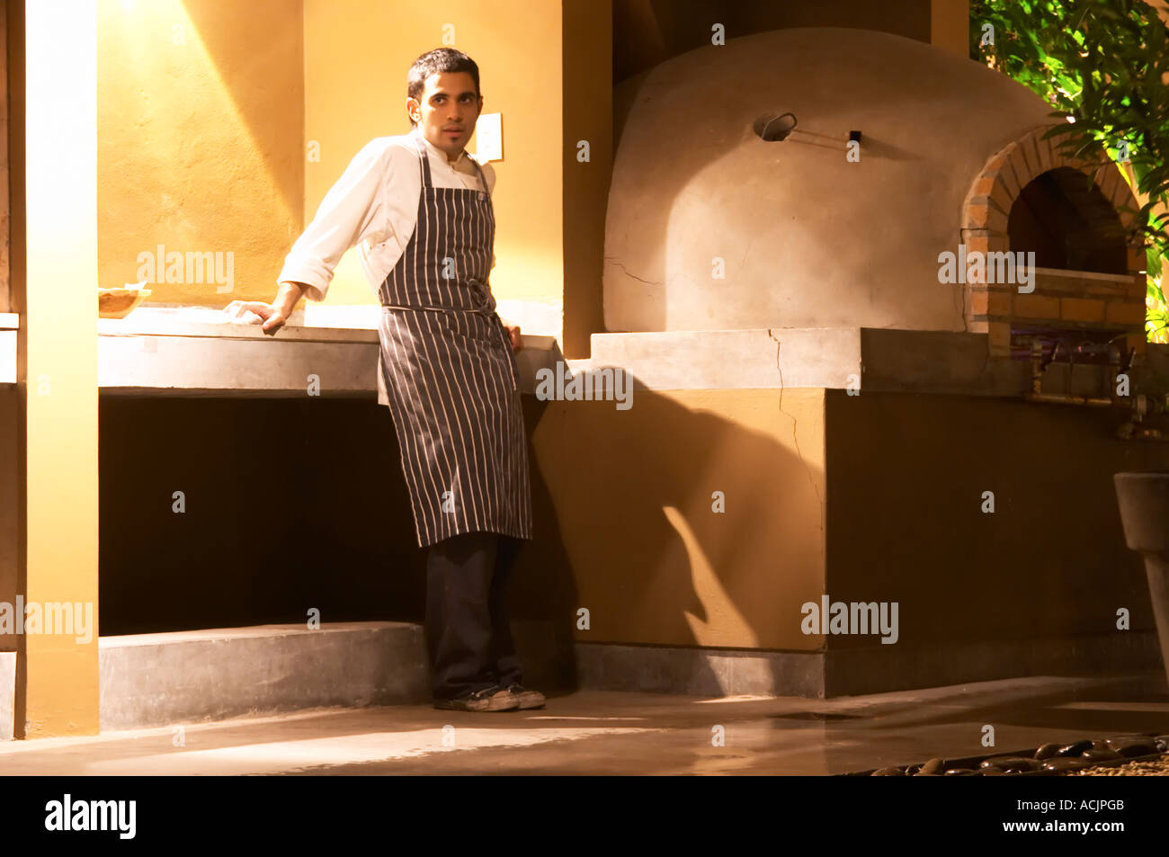 A cook waiting beside the special oven in the garden used to bake bread ...