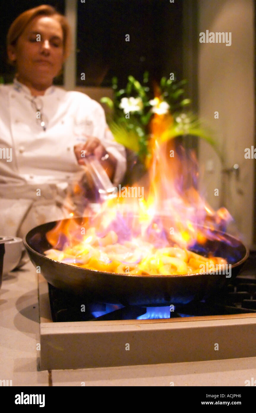 Dolly Irigoyen frying slices of apples in a frying pan, flaming the ...