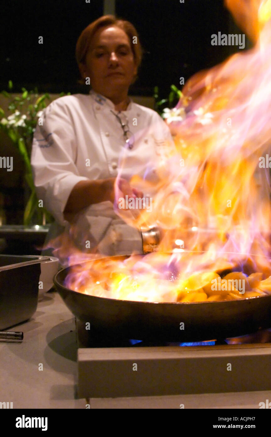 Dolly Irigoyen frying slices of apples in a frying pan, flaming the ...