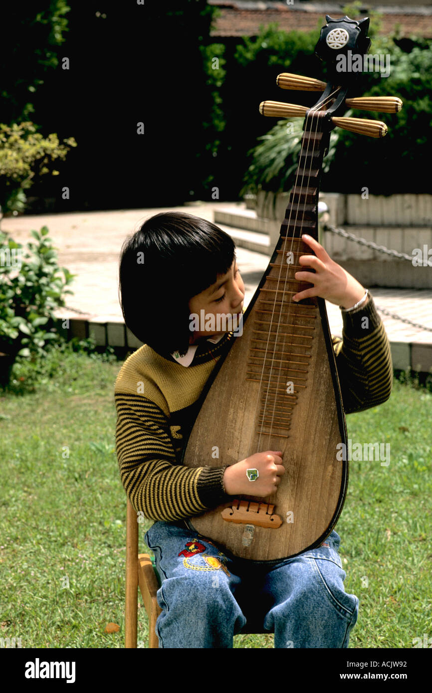 Six year old child playing the Pi Pa instrument in Shanghai China Stock ...