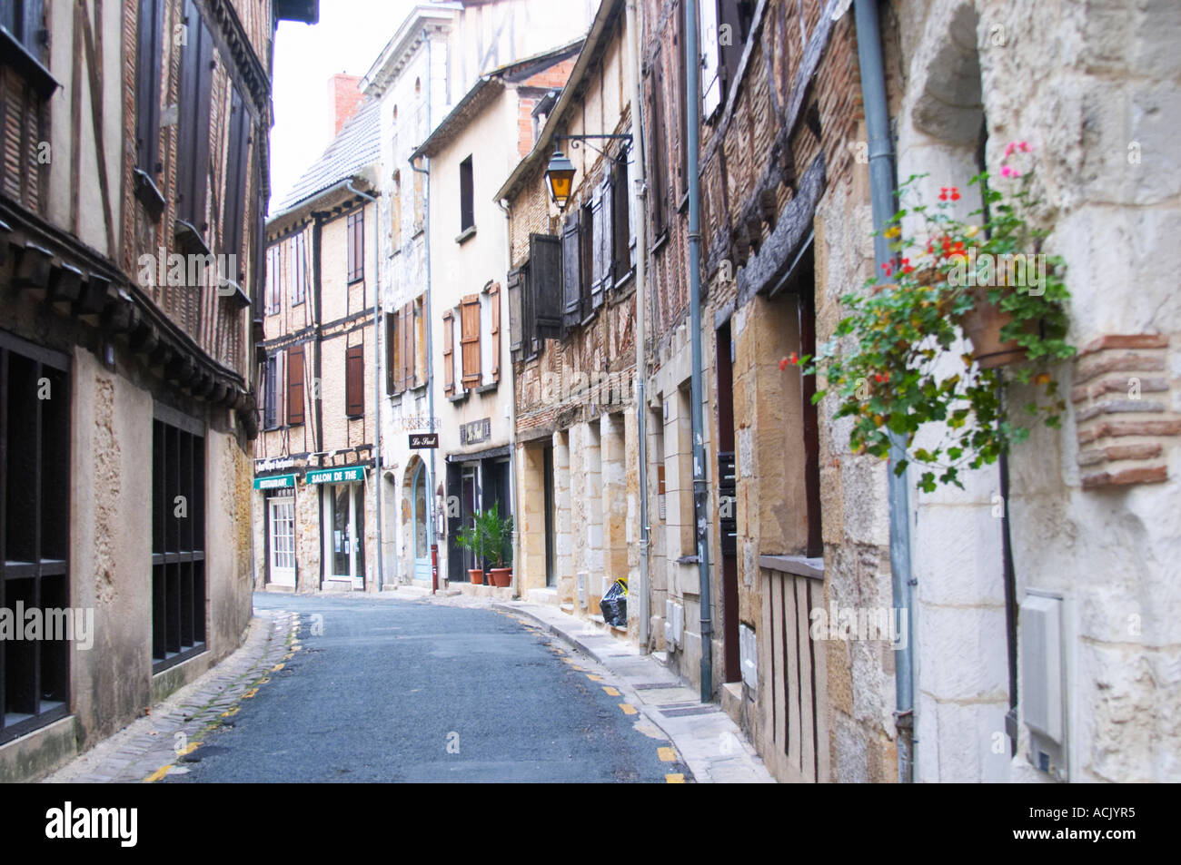 A curving street in the old town with old stone and wooden beam houses ...