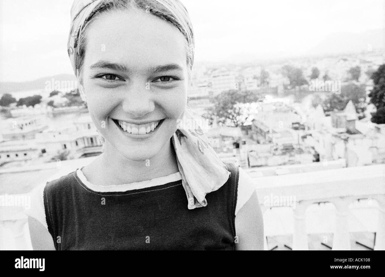 A woman smiling while looking forward above a city Stock Photo - Alamy