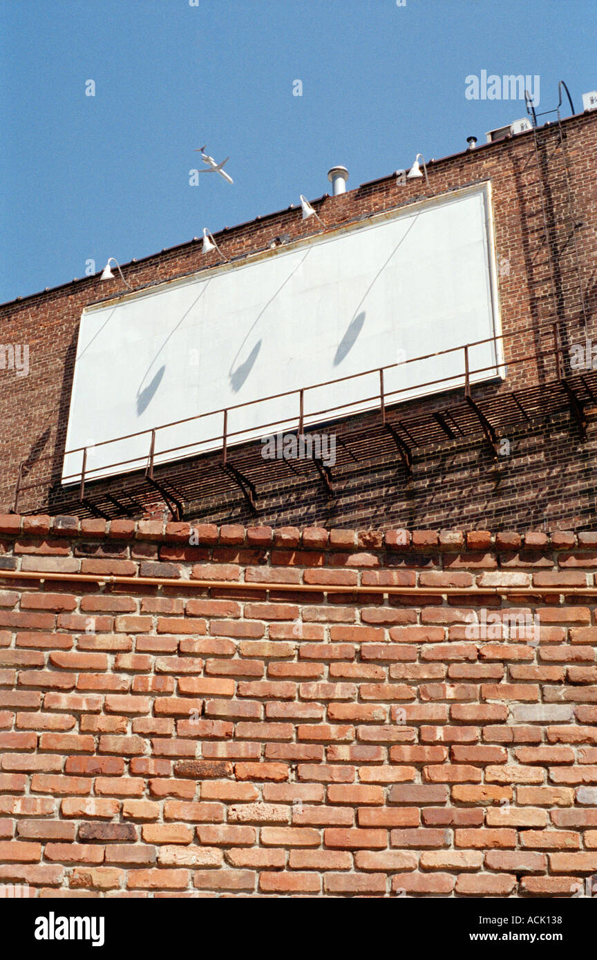 A blank billboard hanging from the side of a brick building Stock Photo ...