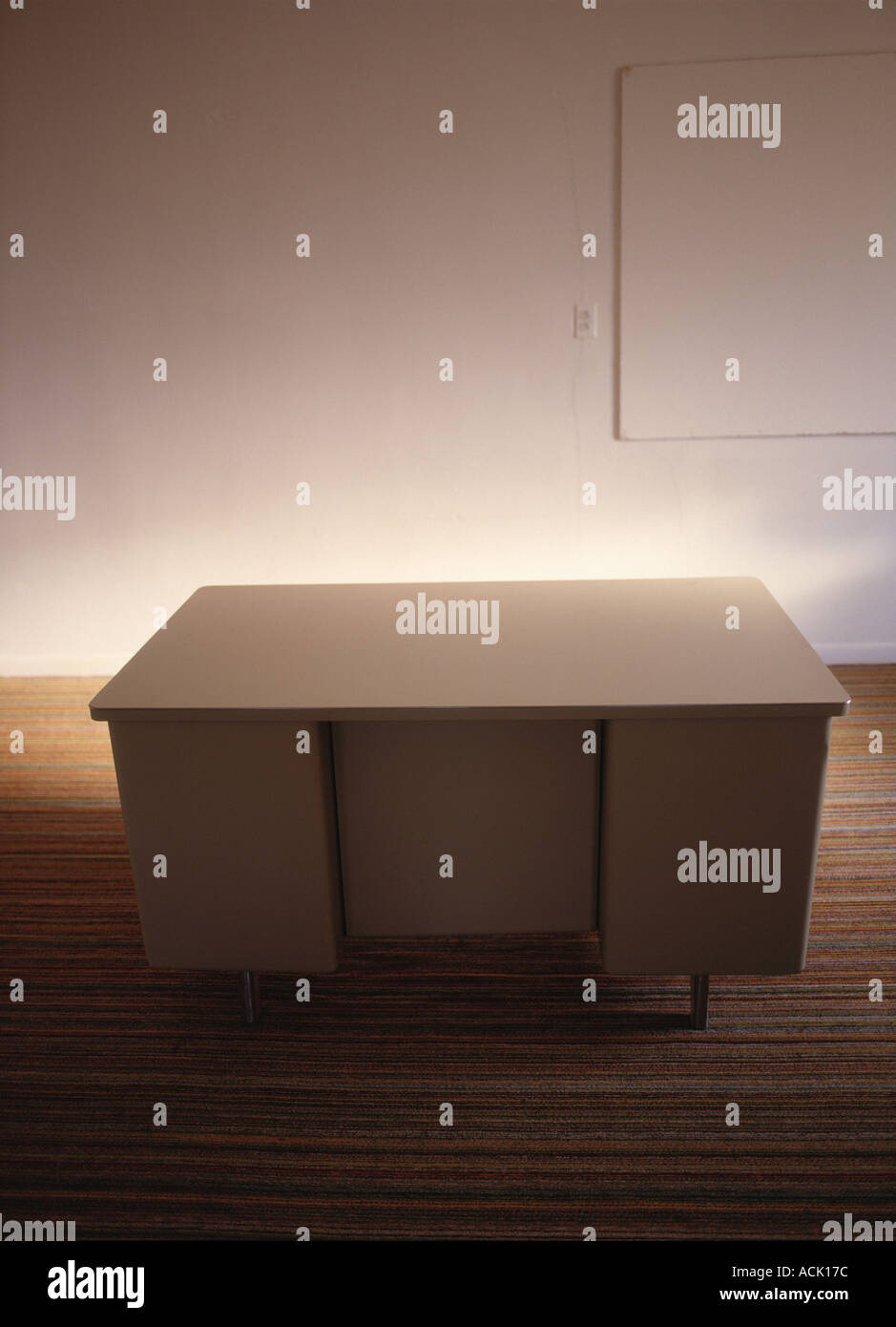 A desk on a carpet in an empty room Stock Photo - Alamy
