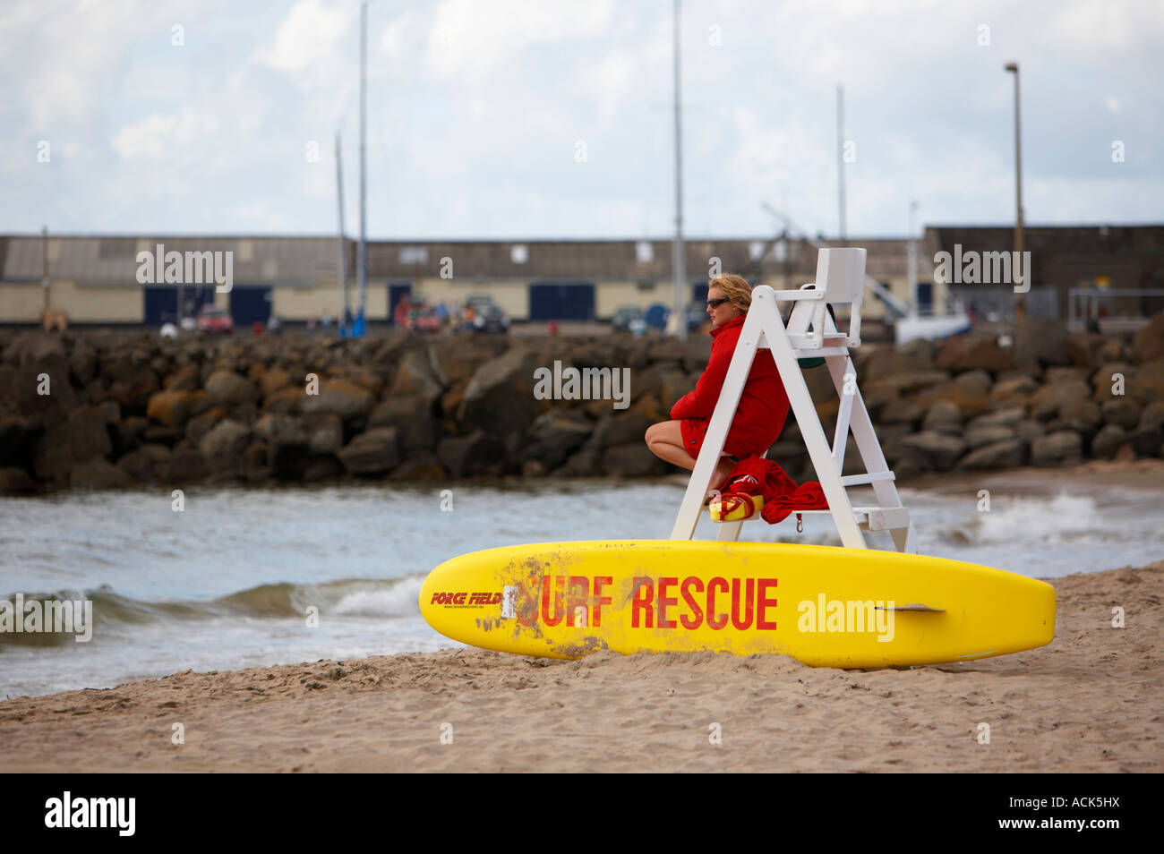 female surf rescue lifeguard sitting in high chair watching over the ...