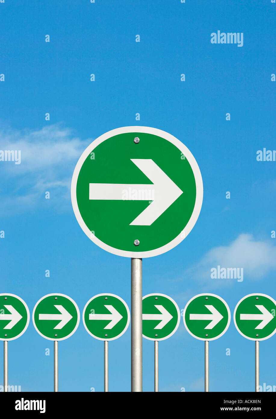 Circular arrow sign with row of smaller identical signs behind it Stock ...