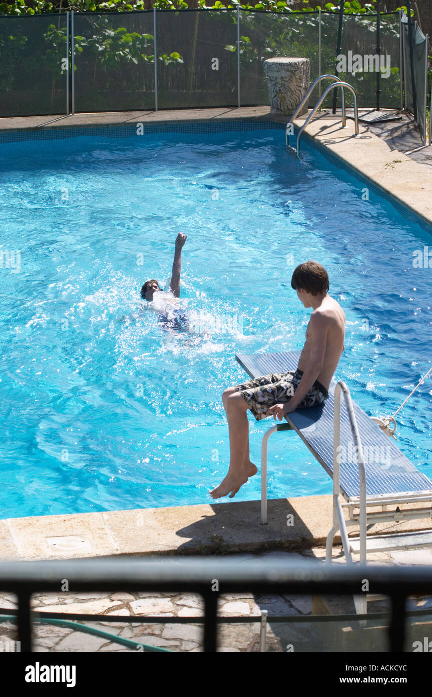 A blue swimming pool with two teenage boys playing Clos des Iles ...