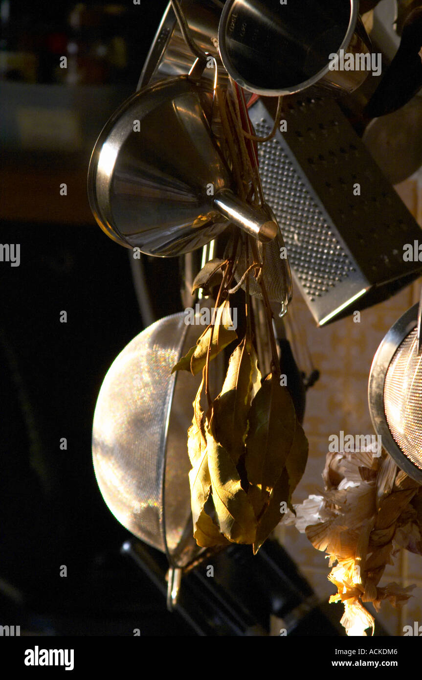 Kitchen utensils in stainless steel hanging on hooks in the Provence ...