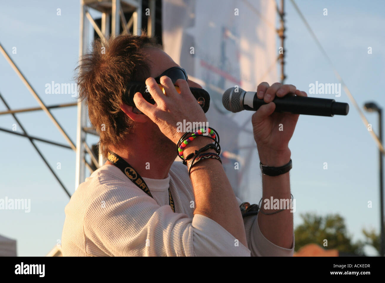 Gin Blossoms lead singer Robin Wilson singing into a fan's cell phone ...