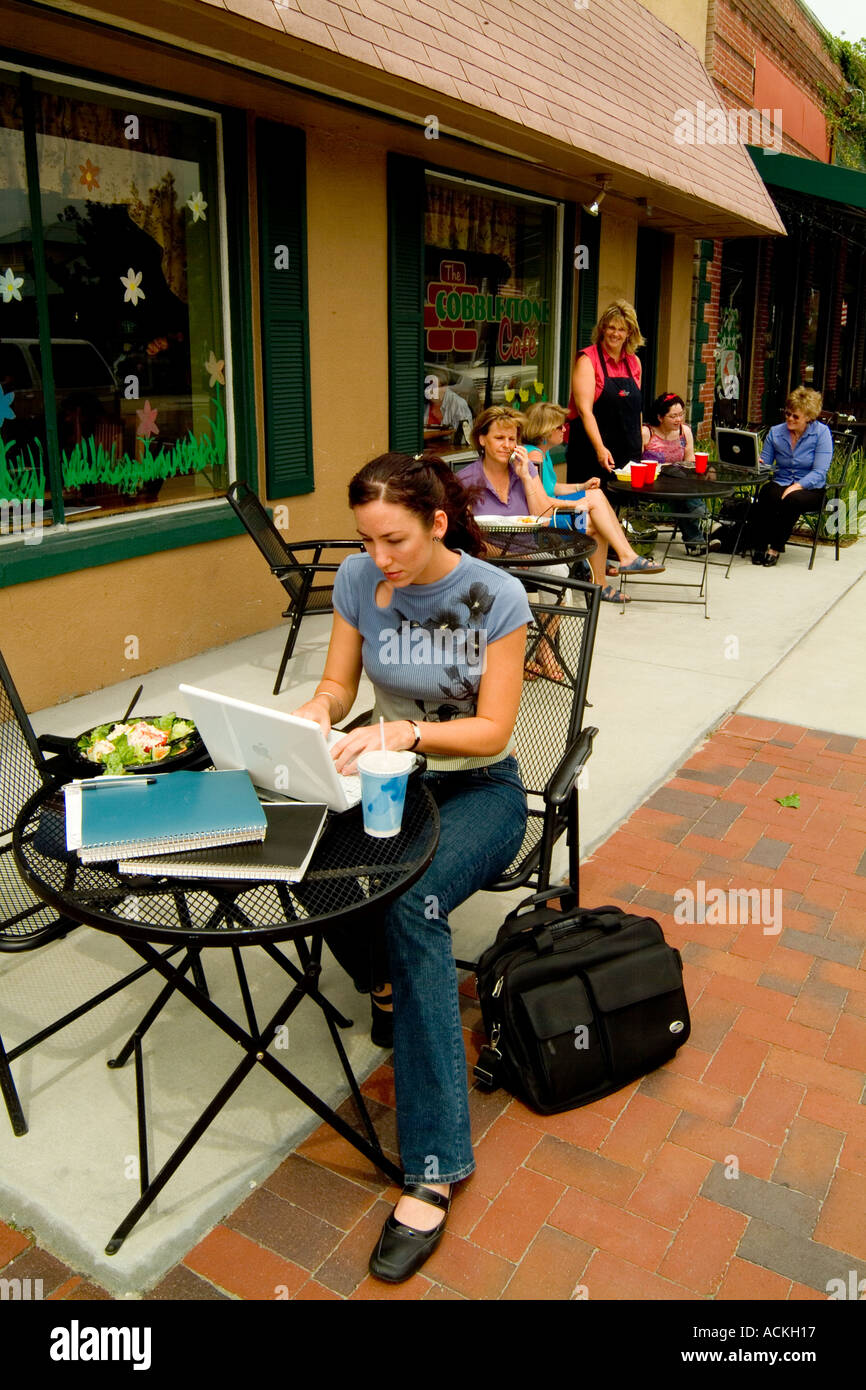 College student outside of local Internet cafe on laptop computer Stock ...