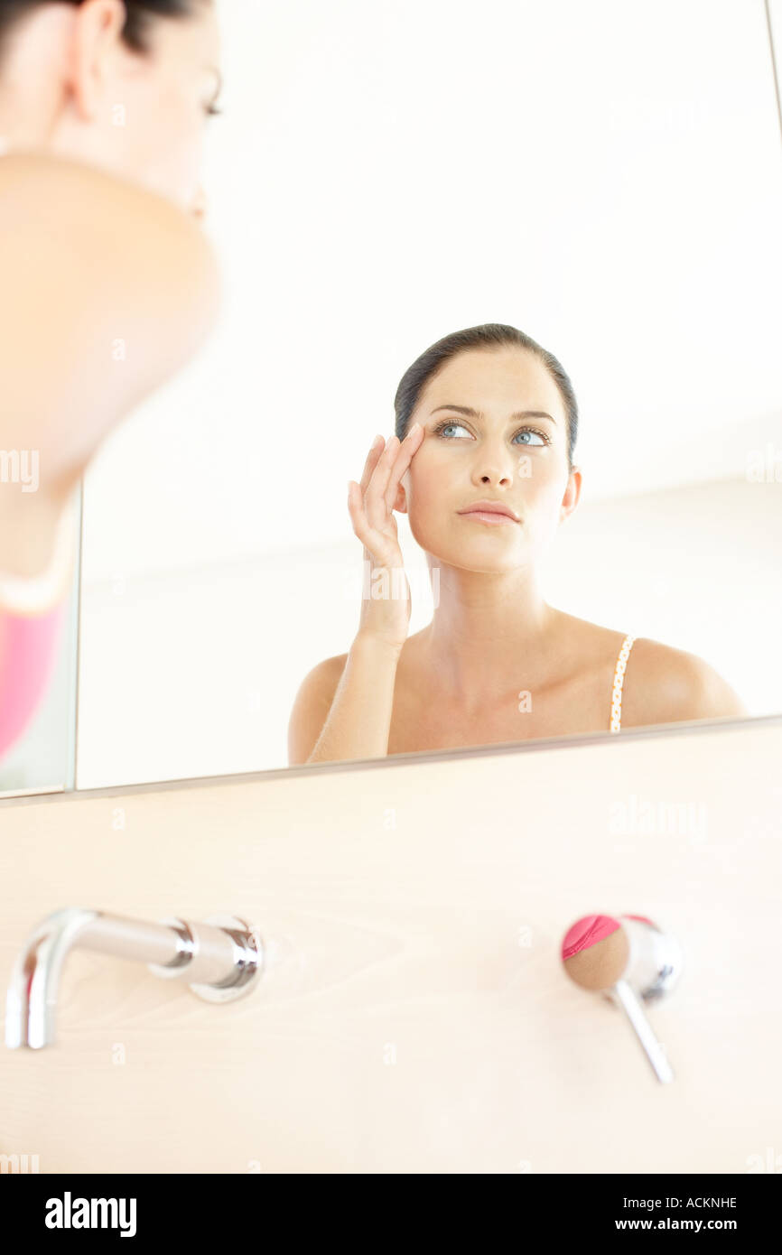 A young woman applying eye cream Stock Photo - Alamy
