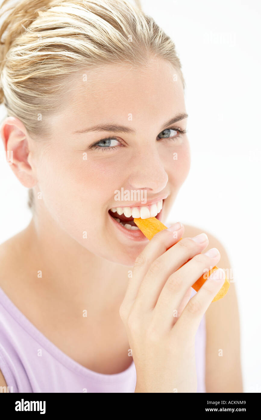 A young woman biting a carrot Stock Photo - Alamy