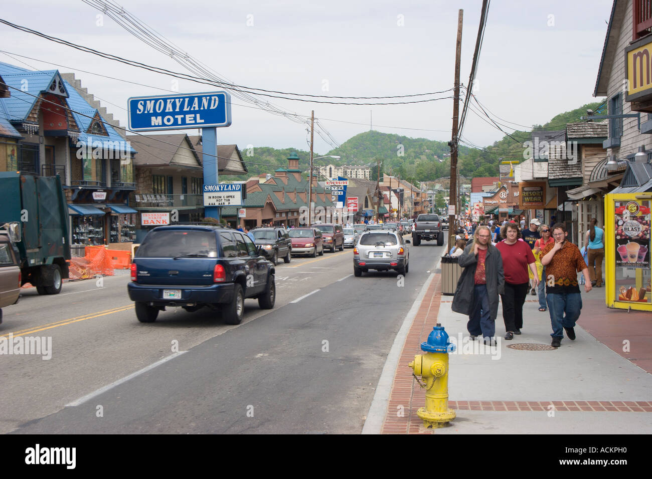 Three young sloppy fat dirty people walking along main street of ...