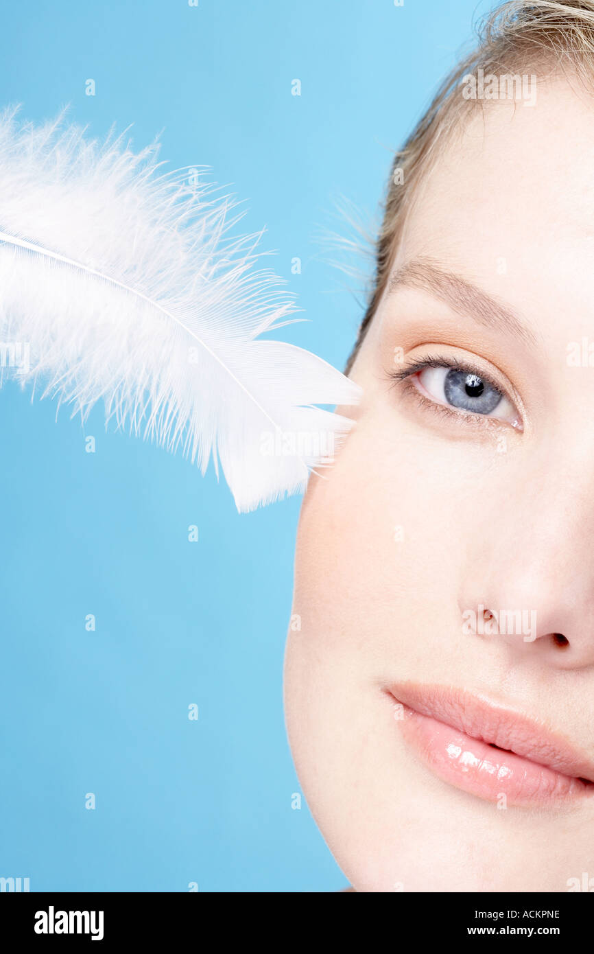 Close up of a feather touching a young woman s face Stock Photo - Alamy