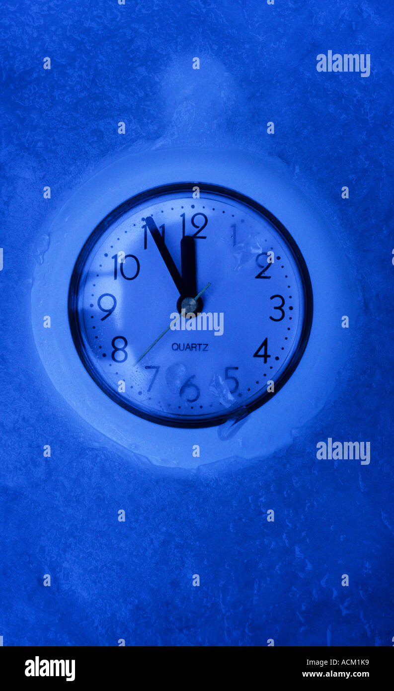 Clock frozen in ice and now melting Stock Photo - Alamy