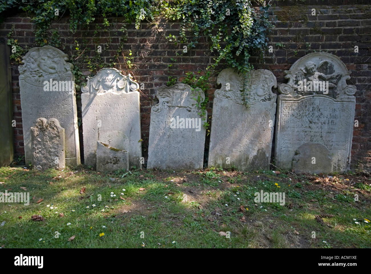 Grave headstones resting against a wall in a churchyard in Enfield ...