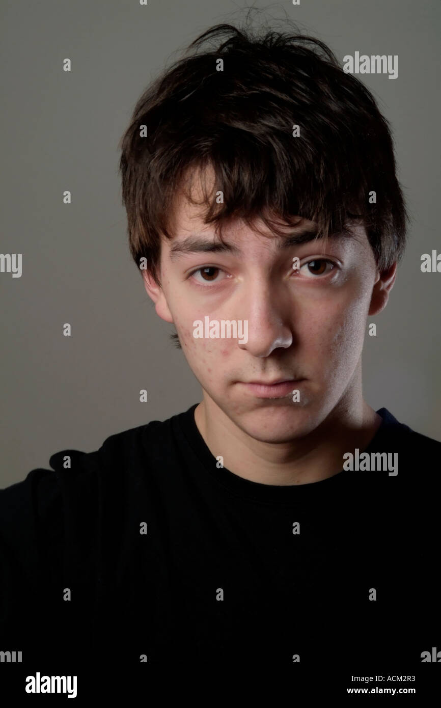Teenage boy staring into the distance with a bored expression on his ...